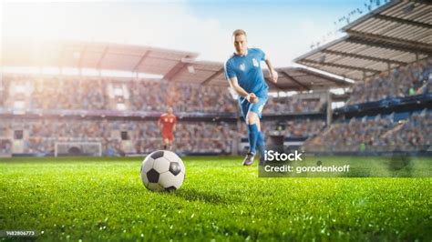 풋볼 월드 챔피언십 축구 선수는 공을 차기 위해 달린다 경기장 잔디밭에서 공 전체 경기장 관중의 환호 국제 토너먼트 시네마틱 샷은 승리를 포착합니다 남자에 대한 스톡 사진