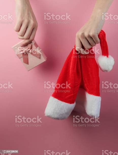 크리스마스 개념입니다 분홍색 파스텔 배경에 산타 모자와 선물 상자를 들고 있는 여성 12월에 대한 스톡 사진 및 기타 이미지 12월 개인 장식품 겨울 Istock