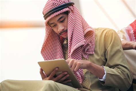 스마트 폰 응용 프로그램을 사용하여 이슬람 남자는 스마트 폰 무슬림 현대 Uae 도시를 들고 손에 일정 의제를 구성합니다 아랍