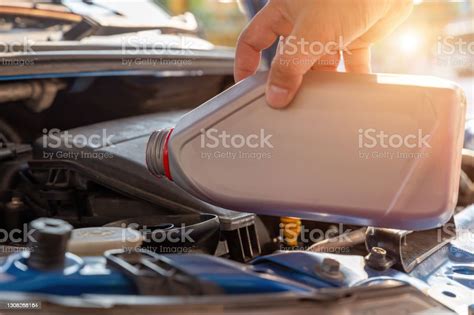 기계의 오일을 변경합니다 자동차 정비사 교체 및 신선한 오일을 붓는 유지 보수 자동차 수리 자동차 Refil 신선한 오일 엔진 오일 급유 지점 교통수단에 대한 스톡 사진 및