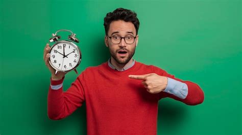 A Man Pointing At A Clock That Says He Is Pointing To The Right