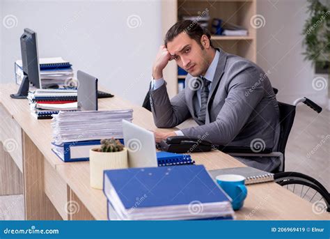 Jovem Trabalhador Do Sexo Masculino Em Cadeira De Rodas No Local De Trabalho Imagem De Stock