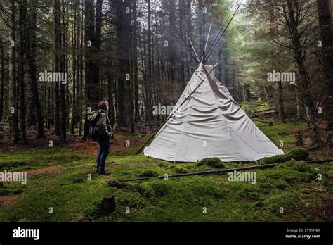 Man With Rucksack Standing Next To Tipi Tent In Nature And Forest Landscape Stock Photo Alamy