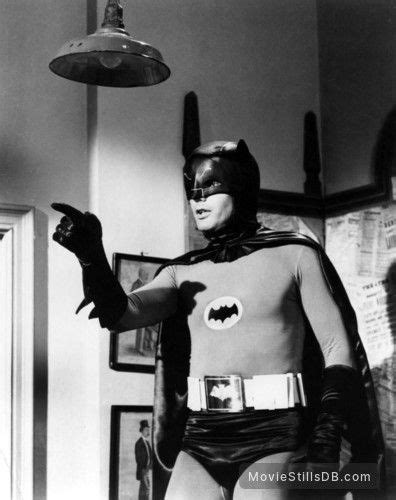A Man Dressed As Batman Pointing At Something