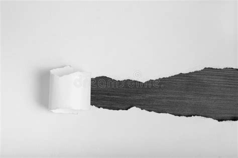 White Torn Paper Revealing Underneath A Black Wooden Background Stock