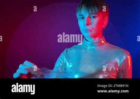 Portrait Young Adult Woman Putting Pills Into Plastic Bag In Neon Illumination Indoors Drugs