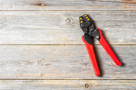 회색 나무 테이블에 전기 를위한 압착 도구 소매 팁에 대한 펜치 또는 펜치를 누릅니다 전기 기술자 또는 빌더 설치를위한 도구입니다 텍스트 공간이 있는 상단 보기 0명에 대한