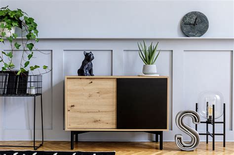 세련된 홈 장식의 디자인 나무 Commode 회색 Pouf 선인장 식물 장식 램프 선반 및 개인 액세서리와 현대적인 스칸디나비아 홈 인테리어 칸 가구에 대한 스톡 사진 및