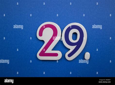 The Number 29 Placed On A Blue Background Photographed From Above Colored Red And Dark Blue