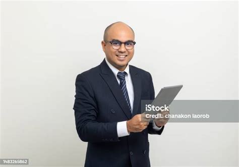 격리된 흰색 배경에 디지털 태블릿을 사용하는 젊은 아시아 사업가의 초상화 사무실 유니폼을 입고 태블릿 컴퓨터를 들고 있는 잘생긴 중년 인도 사업가 경영자에 대한 스톡 사진