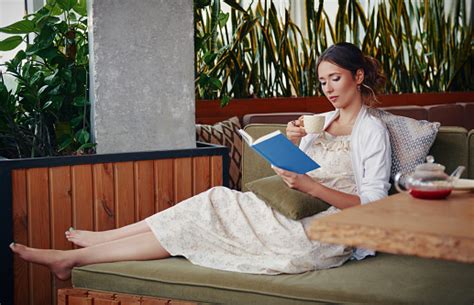 소파에 누워 빨간 과일 차를 마시고 책을 읽는 아름다운 소녀 카페에서 귀여운 젊은 여자 사랑스러운 여자의 실내 초상화 20 29세에 대한 스톡 사진 및 기타 이미지 Istock