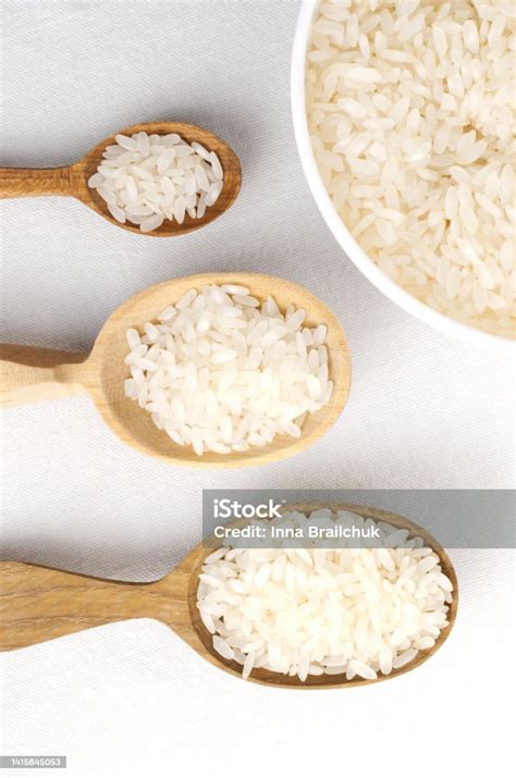 흰색 배경에 마른 카몰리노 쌀과 그릇과 함께 다양한 크기의 세 개의 나무 숟가락 건강한 식습관의 개념 수직 방향 상단 보기 0명에 대한 스톡 사진 및 기타 이미지 Istock
