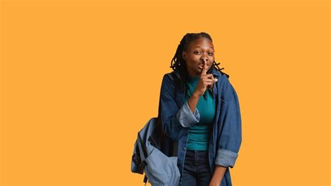 Жестокая женщина делает молчание жестикулирует рукой на заднем плане студии Бесплатно Фото