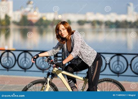 Молодая женщина Redhead ехать велосипед на обваловке Active люди ...