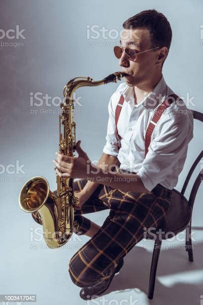 세련 된 젊은 수행자의 자에 앉아서 회색에 색소폰을 연주의 높은 각도 보기 복고풍에 대한 스톡 사진 및 기타 이미지 복고풍 공연 공연자 Istock
