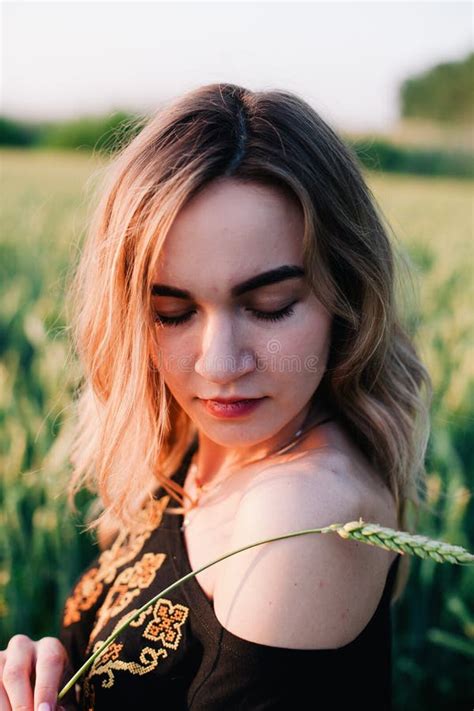Young Slender Girl Embroidered Dress In A Large Wheat Field At Sunset