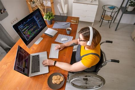 Premium Photo Young Female Programmer In Wheelchair Looking At Data On Laptop Display While