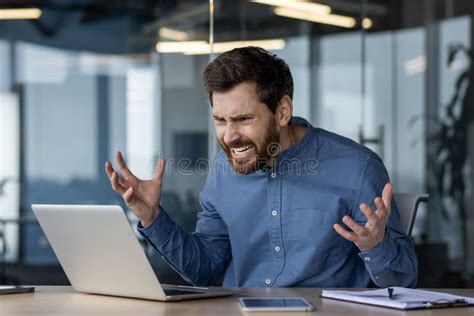 Frustrated Businessman Experiencing Computer Problems At Work Stock