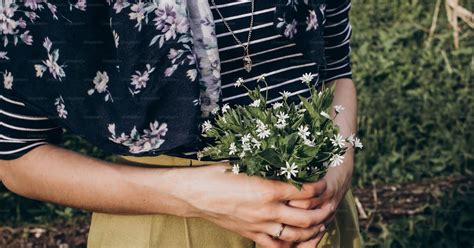 햇볕이 잘 드는 시골에서 야생화의 봄 꽃다발을 들고 있는 세련된 힙스터 여성 텍스트 공간 아름다운 순간 환경을 저장합니다 손에 간단한 꽃을 가진 소박한 소녀 사진