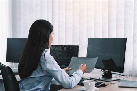 Asian Woman Software Developers Sitting In Front Of Computers Looking At Computer Codes On The