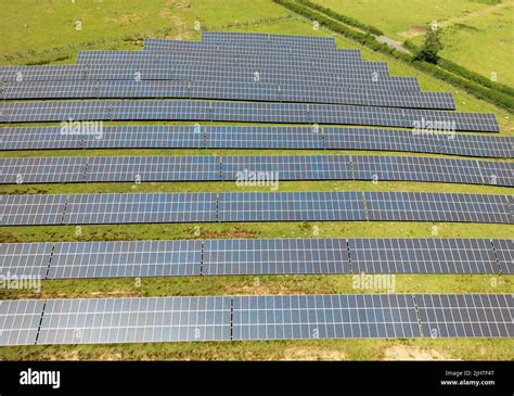 aerial view of rows of solar panels instaked in a farm field no people