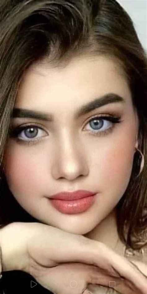 A Beautiful Young Woman With Blue Eyes Posing For A Photo