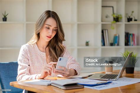 아시아 사업가는 인터넷에서 이메일이나 소셜 미디어를 확인하는 동안 휴대 전화를 사용합니다 회계 재무 개념 및 계산기로 계산 현대