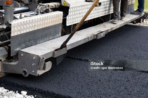 도 공사 중 아스팔트 포장 재료 기계를 운영 하 고 복구 작업자 작동 합니다 포장 재료 피니셔 아스팔트 피니셔 또는 포장 기계는 아스팔트의 레이어를 배치 합니다 싫지만 도로