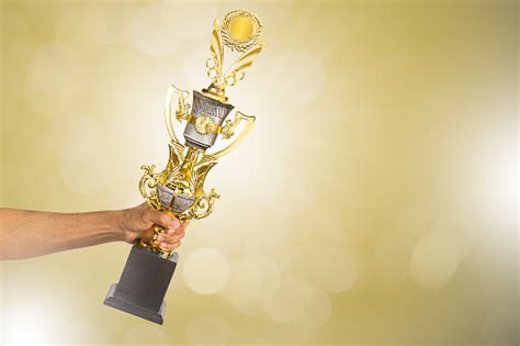 남자의 손을 잡고 흐리게 골든 Bokeh 배경에 황금 우승자 트로피 컵 1위에 대한 스톡 사진 및 기타 이미지 1위