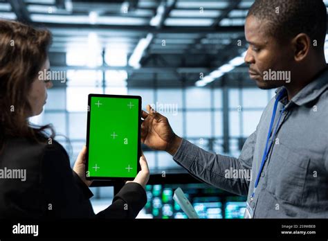 Engineers In Data Center Using Mockup Tablet Observing Analytics