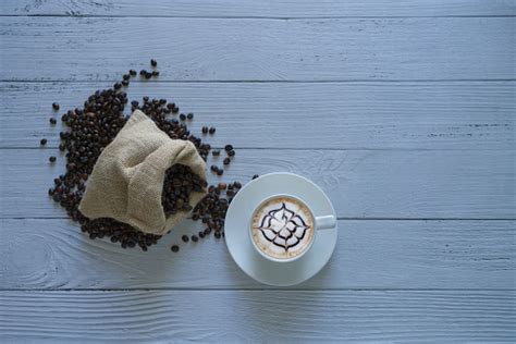 커피 컵에 라떼 아트 커피와 왼쪽 흰색 나무 배경에 자루 가방으로 고립 된 커피 콩 0명에 대한 스톡 사진 및 기타 이미지