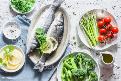 점심바다 농 어 아스파라거스 토마토 브로콜리 녹색 완두콩 올리브 오일 향신료에 대 한 균형 잡힌된 건강 한 재료의 집합입니다 밝은 배경에 보기 가기 평면 배치 건강한