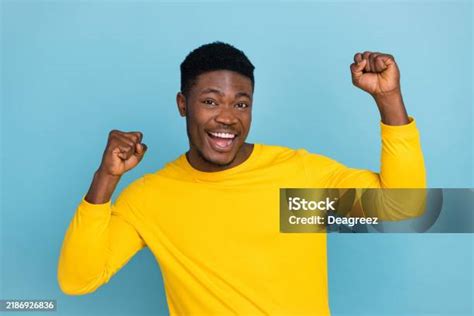 만세의 사진 젊은 갈색 머리 남자가 노란색 긴 소매 셔츠를 입고 파란색 배경에 고립되어 있습니다 25 29세에 대한 스톡 사진 및 기타 이미지 Istock