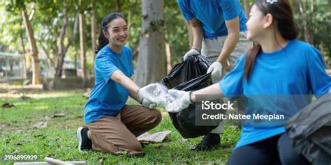쾌활한 가족 자원봉사자들이 공원에서 쓰레기를 수거하는 것을 서로 도우며 팀워크와 환경 의식을 고취합니다 3 명에 대한 스톡 사진 및 기타 이미지 Istock