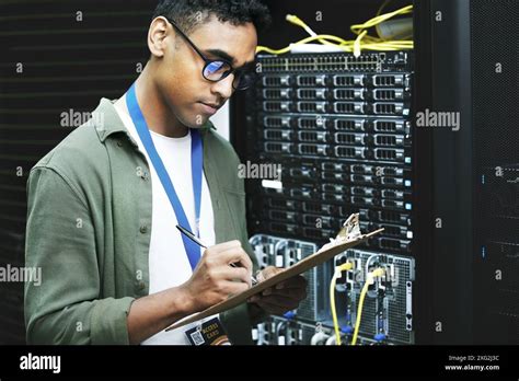 data center man and computer engineer with checklist writing and
