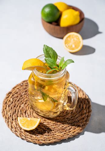 레모네이드 음료 또는 차가운 차에 신선한 레몬 민트 얼음을 항아리에 담습니다 신선한 과일과 그림자가 있는 밝은 배경에 상쾌한 감귤류 모히토 칵테일 홈메이드 건강하고 해독