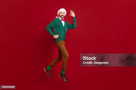 전체 몸 크기 사진 재미 있은 활기찬 남자 입고 크리스마스 기분 옷 펑키 모자 올리기 손바닥 인사 기호 고립 된 빨간색 배경 12월에 대한 스톡 사진 및 기타 이미지