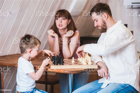 Szczęśliwa Rodzina Matka Tata I Ich Syn Grający W Szachy W Pokoju