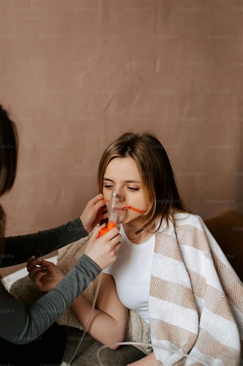 소파에 앉아 있는 두 명의 여성 중 한 명이 주황색 물체를 들고 있다 사진 Unsplash의 천식 이미지