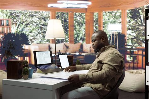Entrepreneur Evaluating Office Blueprints And Planning The Interior