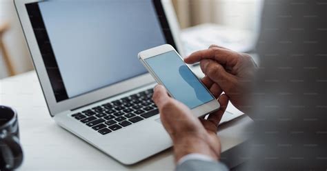 스마트폰과 노트북을 들고 사무실의 테이블에 앉아 일하는 사업가의 중간 부분 복사 공간 사진 Unsplash의 랩톱 이미지