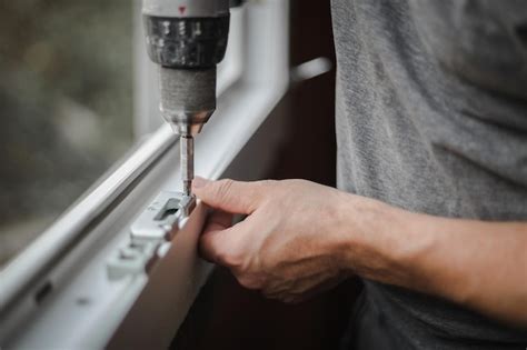 Premium Photo Caucasian Man Installs Fittings For A Window Frame