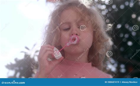 Focused Little Blonde Girl In Pink Blows Soap Bubbles Stock Video