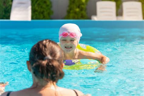 Happy Mother And Daughter Bathe In The Pool On A Sunny Day Stock Image