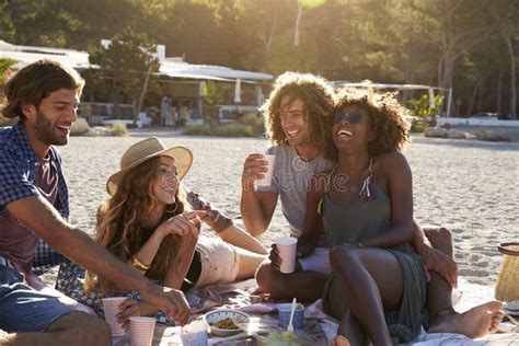 Two Couples Having A Picnic On The Beach Lens Flare Ibiza Stock Image