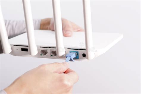 The Back View Of Router Showing The Lan Internet Port And The Hand Is Plugging In The Land