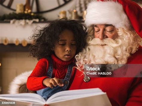 크리스마스 트리 근처에서 아이와 함께 책을 읽는 산타 클로스 산타 클로스에 대한 스톡 사진 및 기타 이미지 산타 클로스 아이 아프리카 민족 Istock