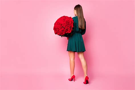 매력적인 레이디홀드 백 장미 무리 산책 데이트 명랑 한 입고 그린 드레스 하이힐 고립 된 파스텔 핑크 컬러 배경의 전신 후면 갈색 머리에 대한 스톡 사진 및 기타 이미지