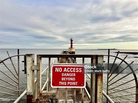 노섬벌랜드에서 등대가 배경으로 있는 금속 게이트에 있는 접근 금지 위험 표지판 0명에 대한 스톡 사진 및 기타 이미지 Istock