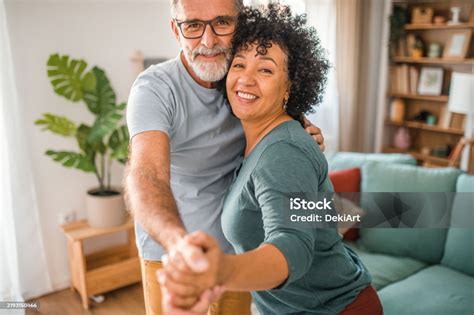 거실에서 춤추고 웃는 미소 짓는 중년 부부의 초상화 집에서 사랑과 애정의 순간을 즐기는 모습 2명에 대한 스톡 사진 및 기타 이미지 Istock